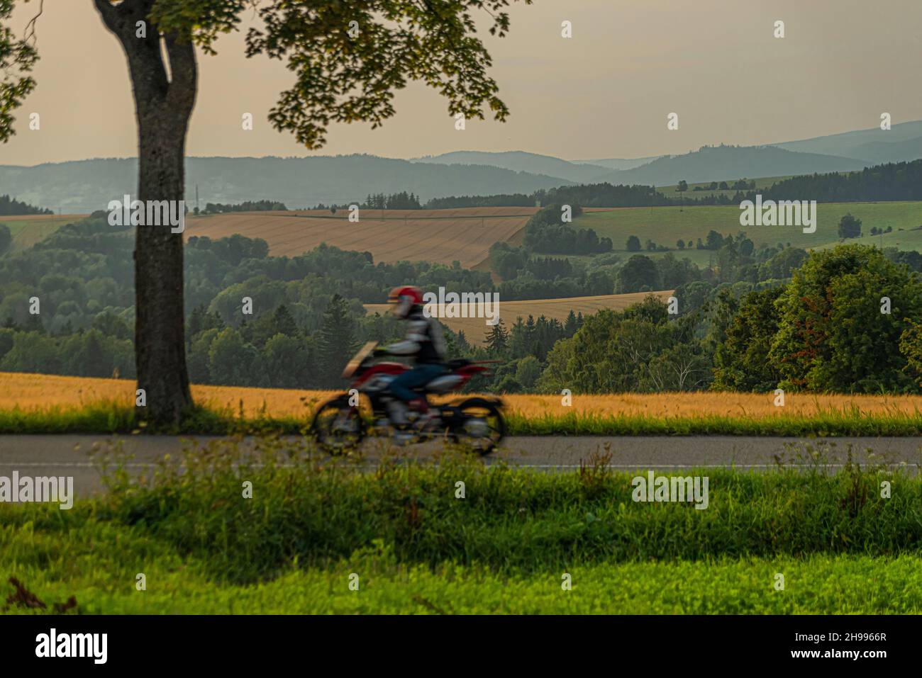 Motorcycle on alley road with leaf trees in sunset summer color evening ...