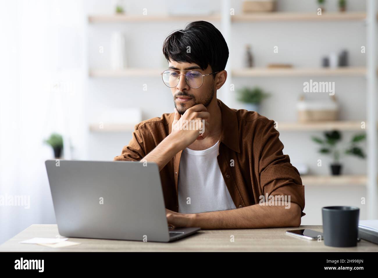 Pensive arabic man employee working on modern notebook Stock Photo - Alamy