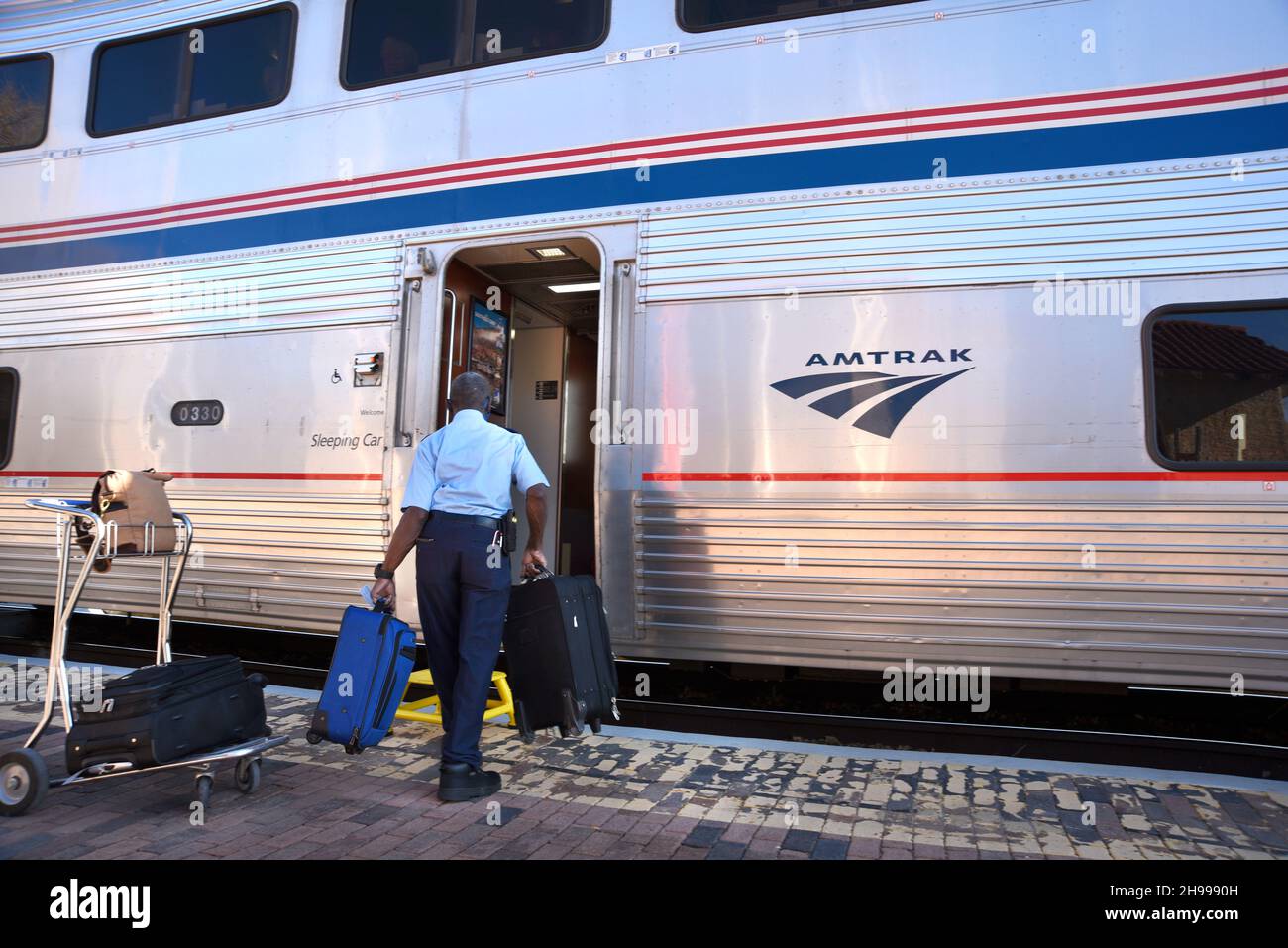 An Amtrak conductor in Lamy, New Mexico, loads luggage into the ...