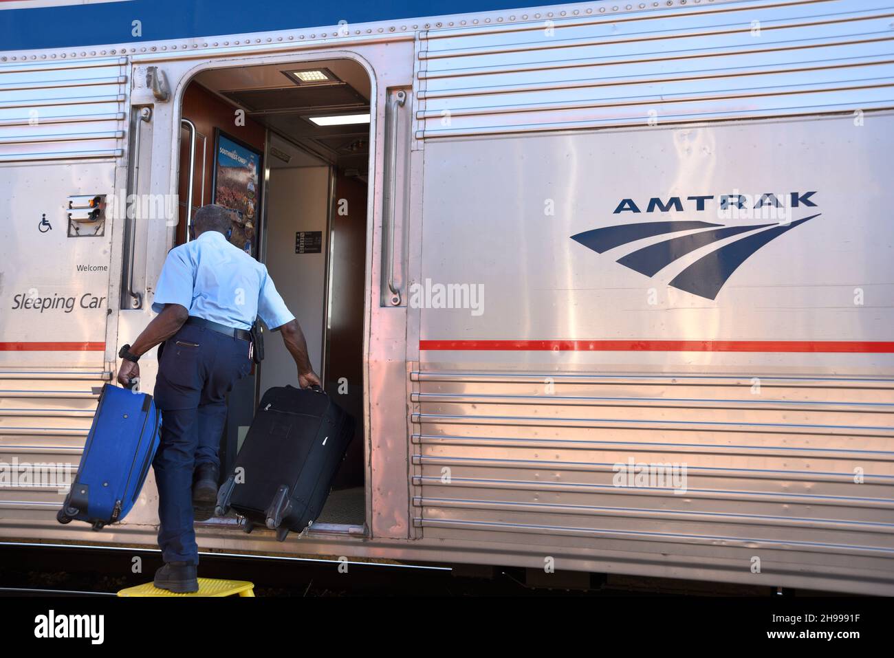 An Amtrak conductor in Lamy, New Mexico, loads luggage into the ...