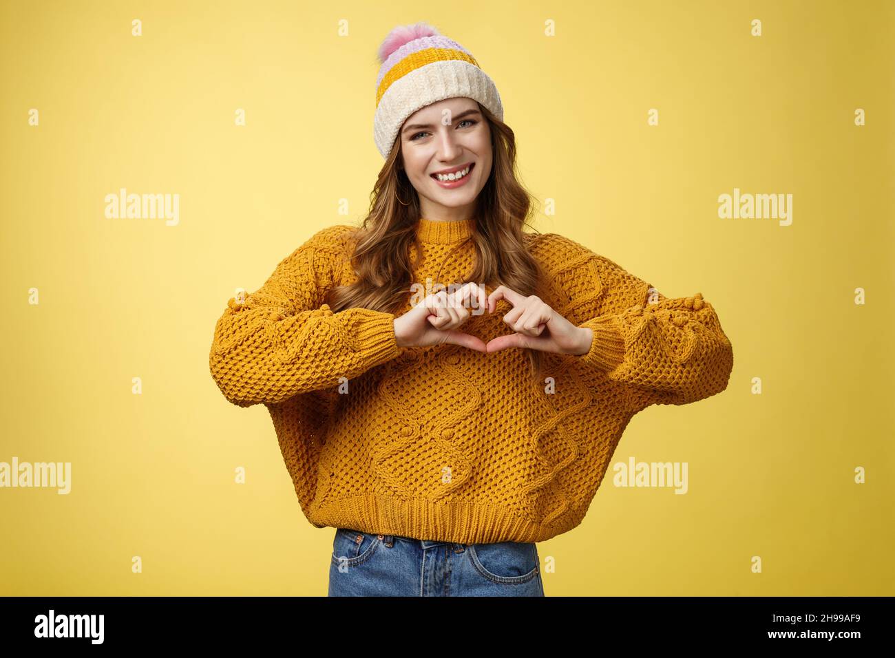 Girl brings peace love show heart gesture tilting head friendly smiling ...