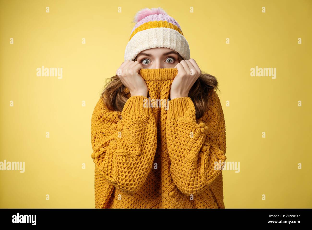 Portrait scared insecure timid cute girl hiding face pull sweater nose ...