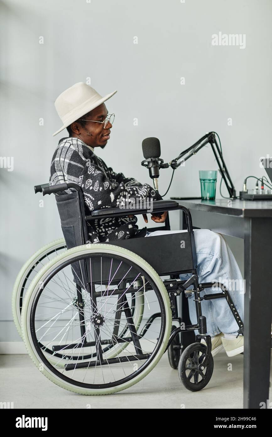 Vertical full length portrait of African-American person in wheelchair ...