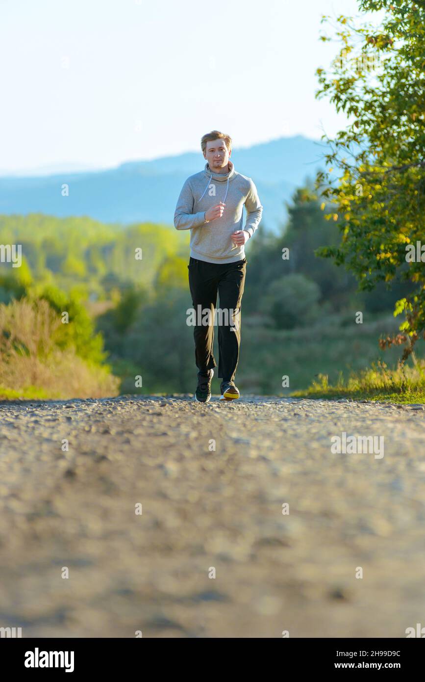 Running man jogging in rural nature at beautiful summer day. Sport ...