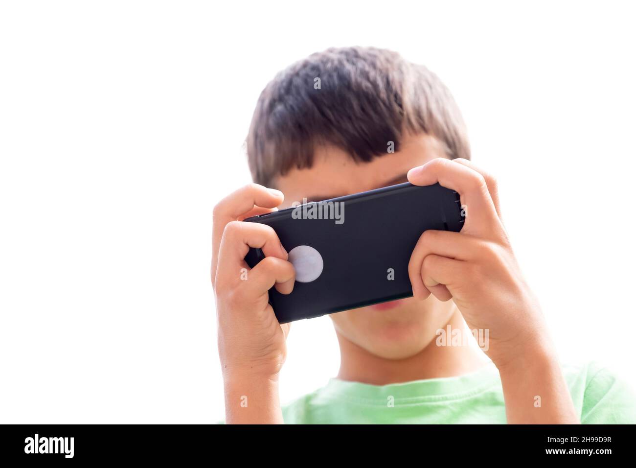 a child playing with a smart phone with her face covered by the cell ...
