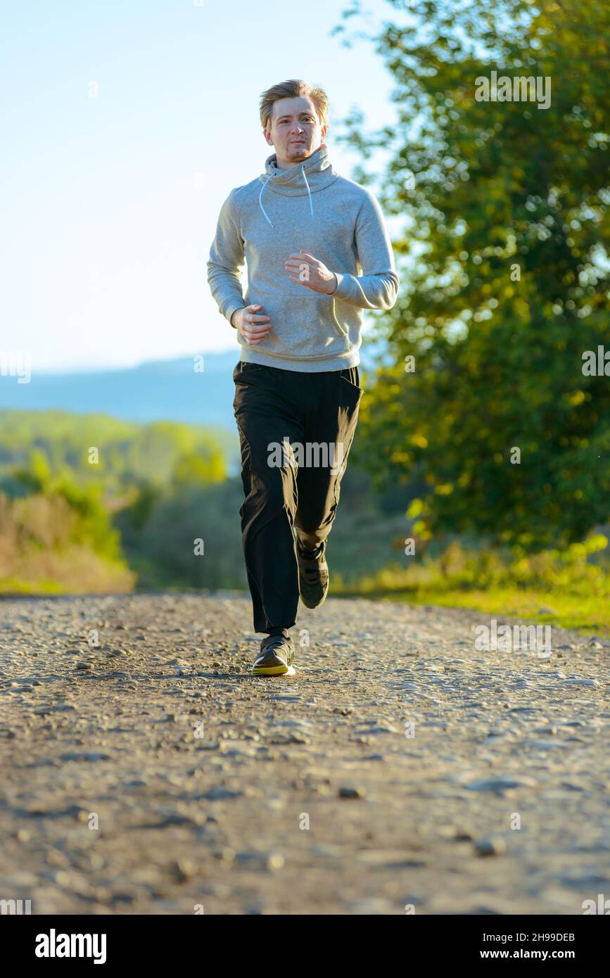 Running man jogging in rural nature at beautiful summer day. Sport ...