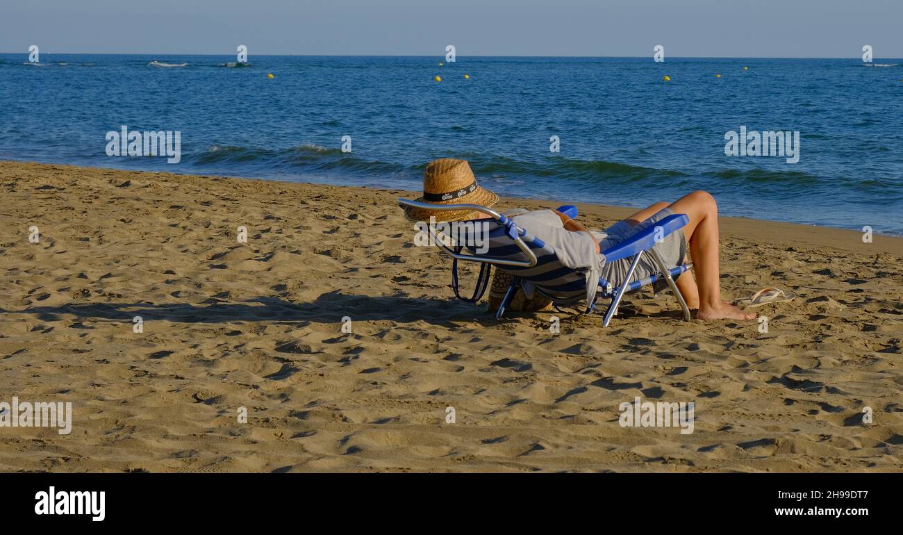 A man relaxing on the beach at Canela Island Ayamonte in Andalusia ...