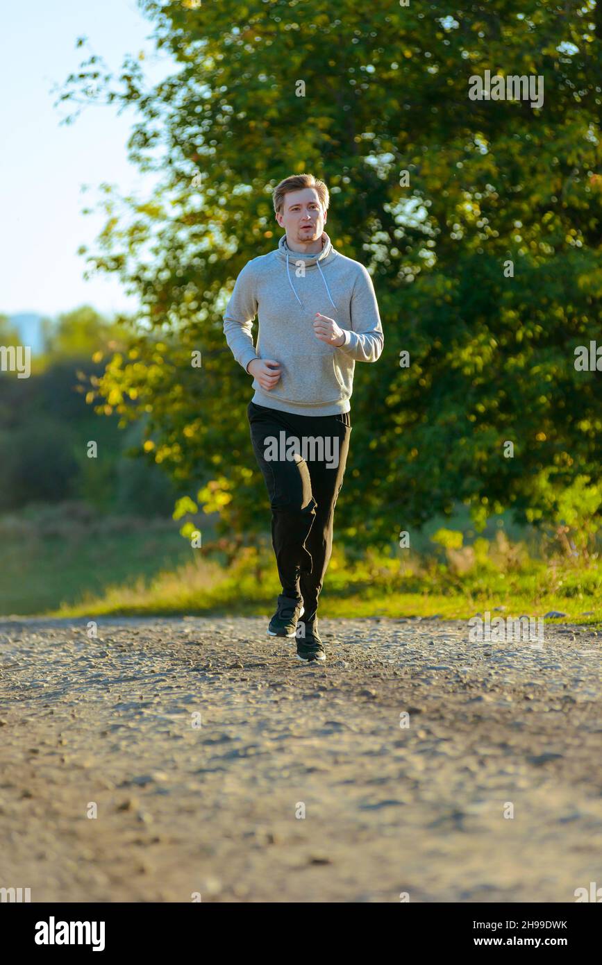 Running man jogging in rural nature at beautiful summer day. Sport ...