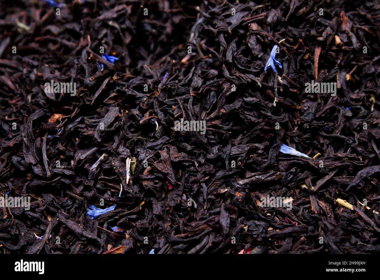 black leaf tea with flower petals close-up, drink Stock Photo - Alamy