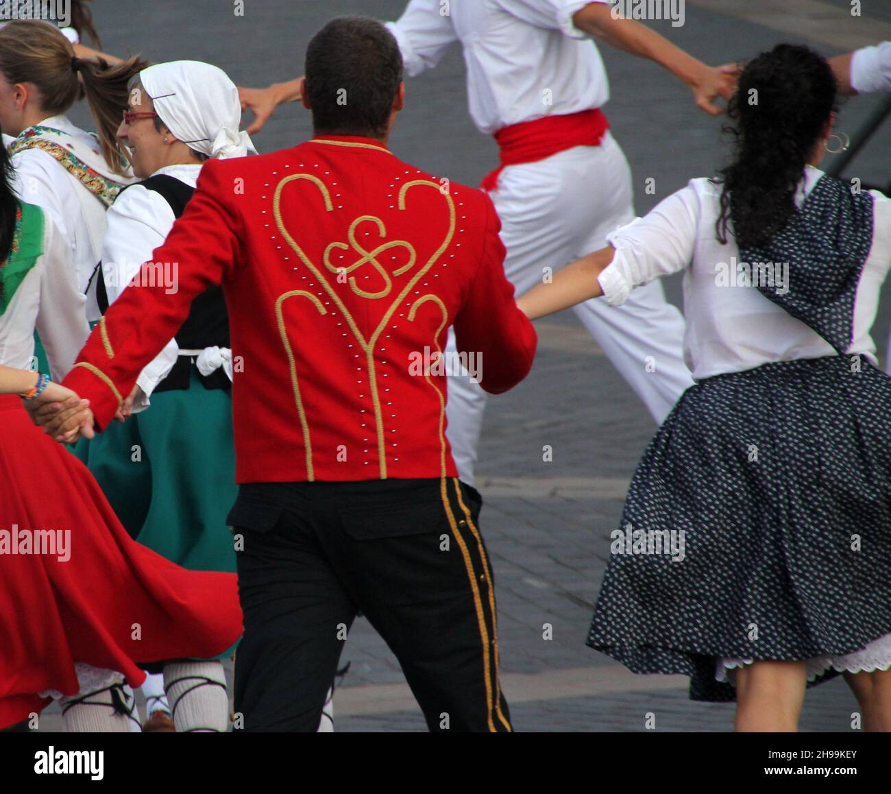 The folk dancers dancing with traditional costumes outside in Basque ...