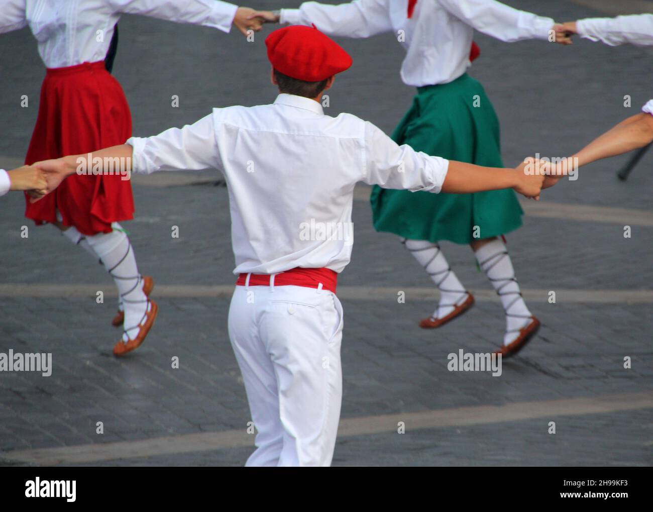 The folk dancers dancing with traditional costumes outside in Basque ...