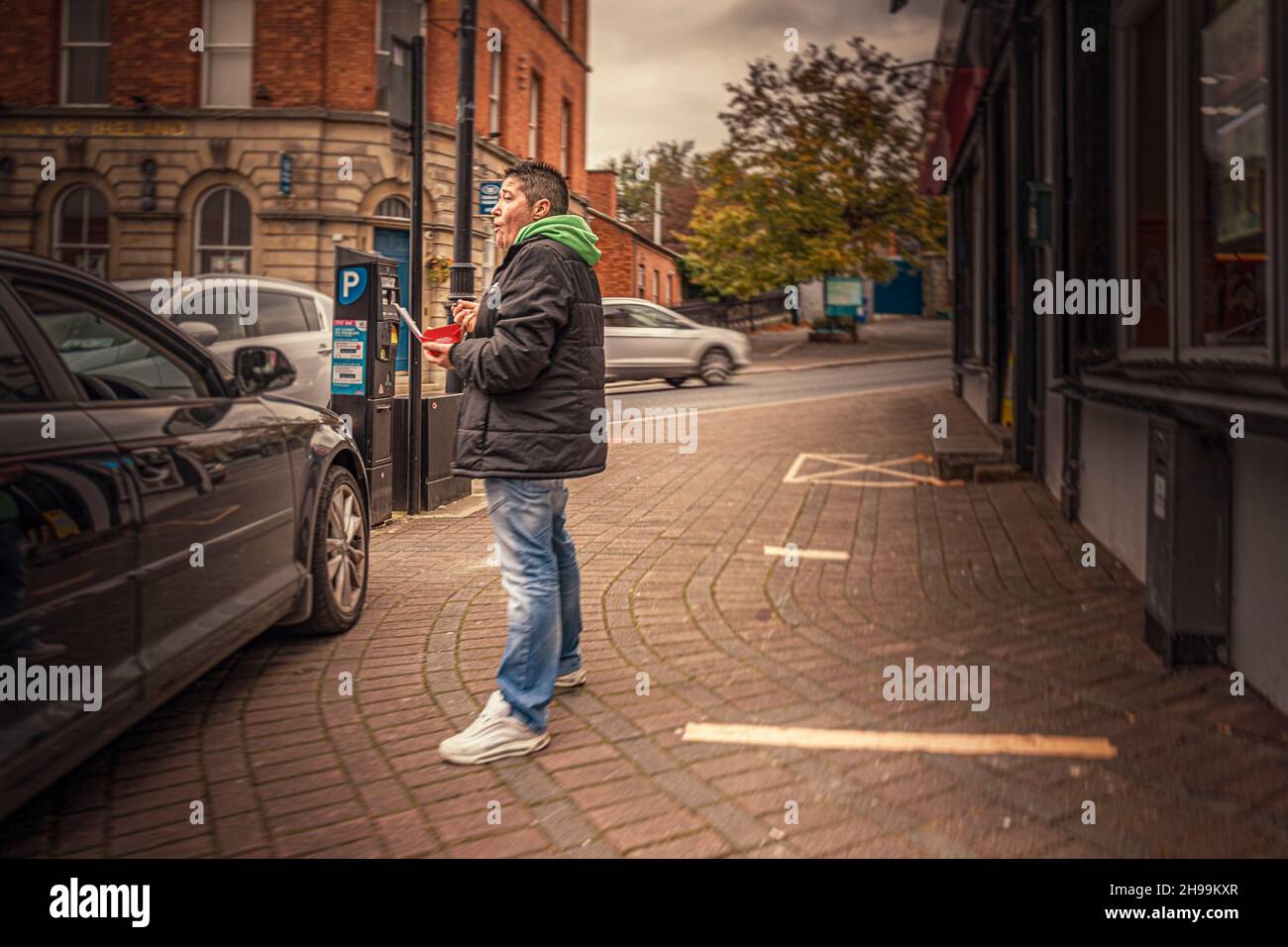 Man eating outside on the street Stock Photo - Alamy