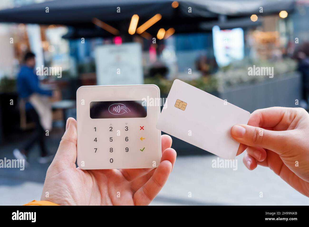 Crop anonymous female client with plastic card making contactless NFC ...