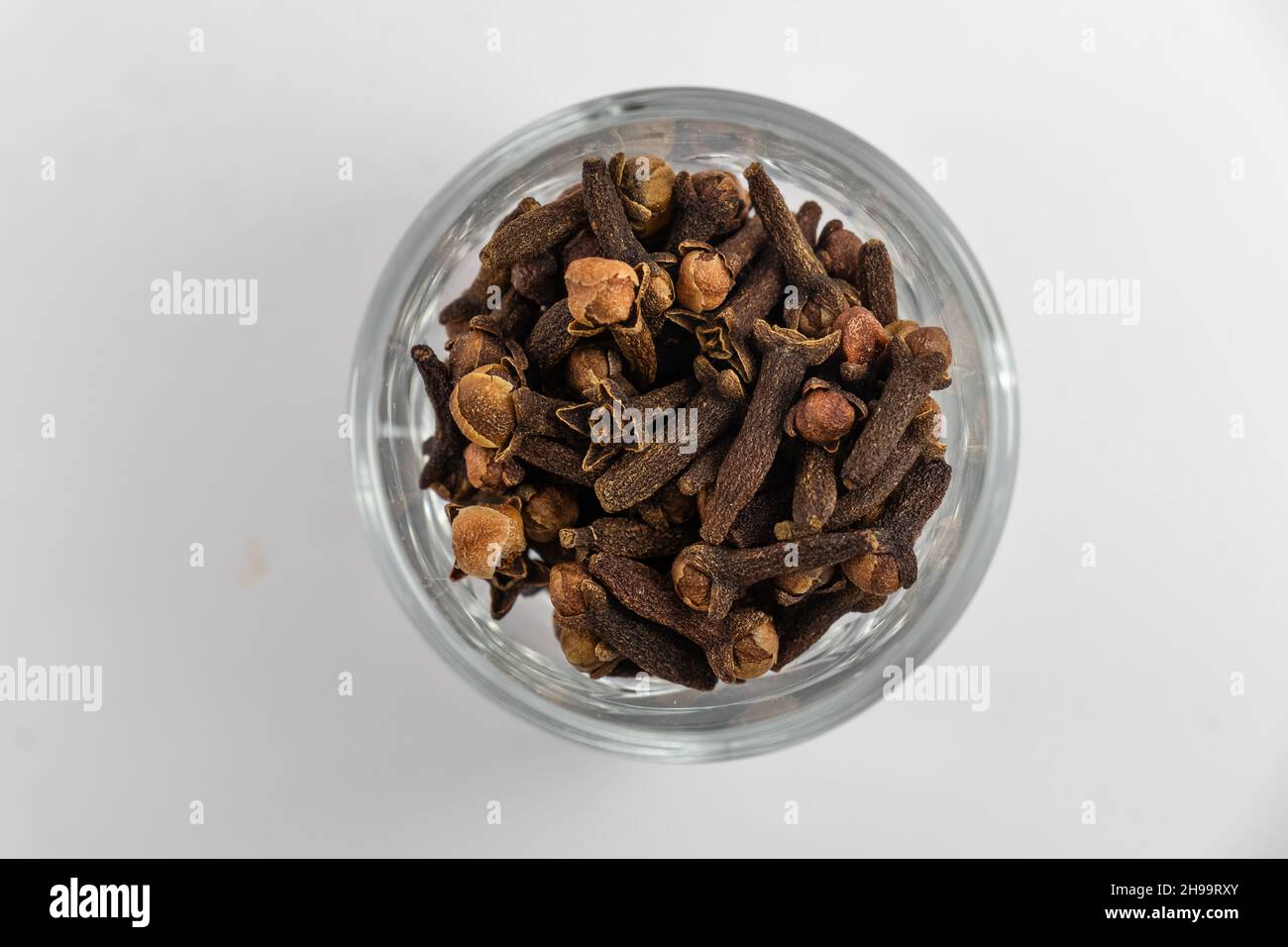 A pile of organic fresh whole clove buds in a glass bowl isolated on ...