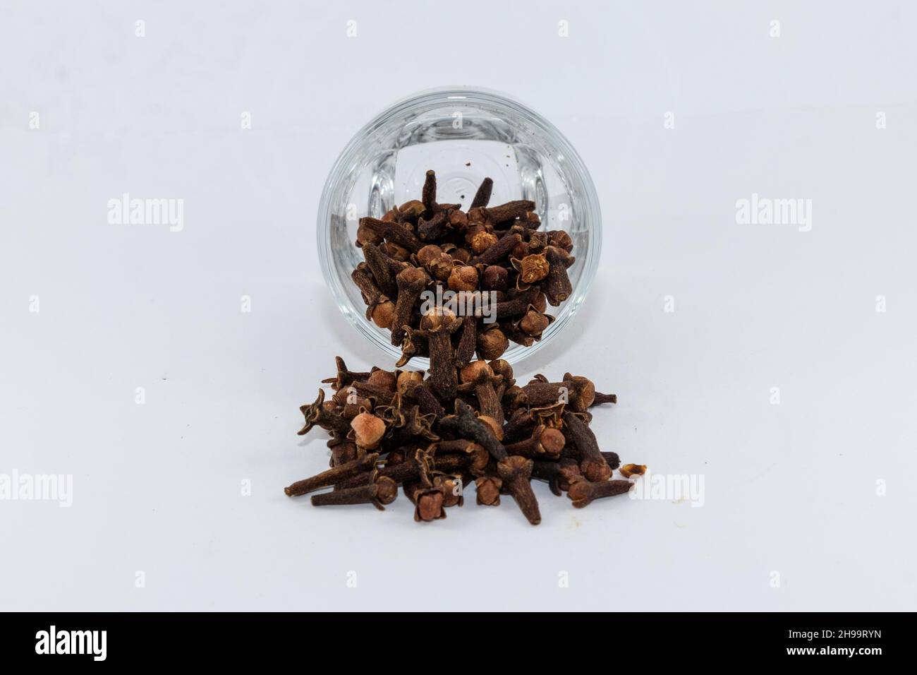 A pile of organic fresh whole clove buds in a glass bowl isolated on ...