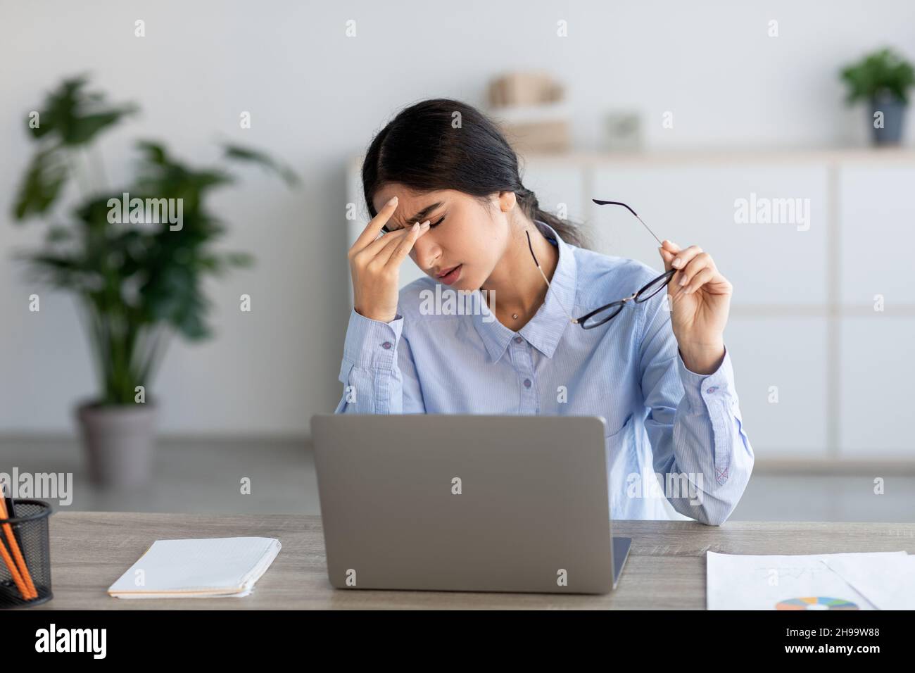 Tired unhappy upset young hindu female manager suffering from headache ...