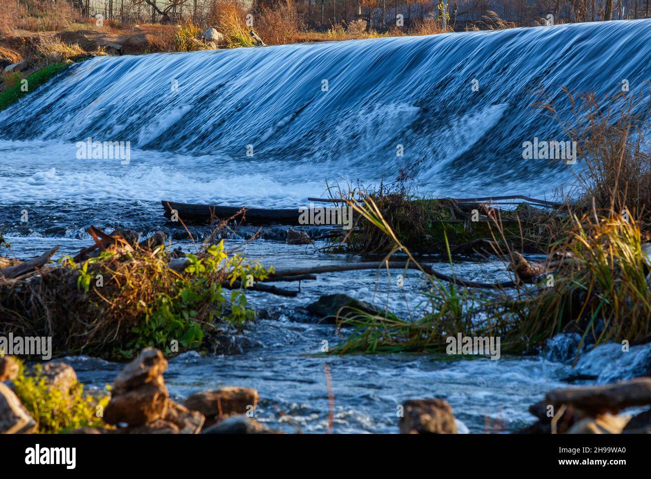 Waterfall on the river in the rays of the setting sun Stock Photo - Alamy