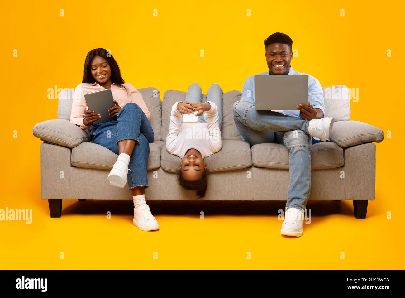 Happy African American family holding and using gadgets Stock Photo - Alamy