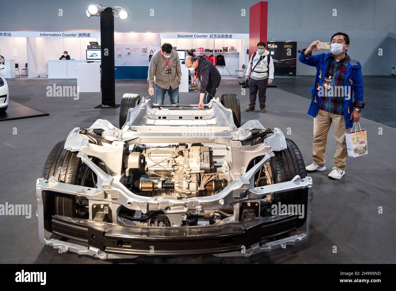 Visitors look and take photos of a Tesla chassis car, vehicle frame and ...