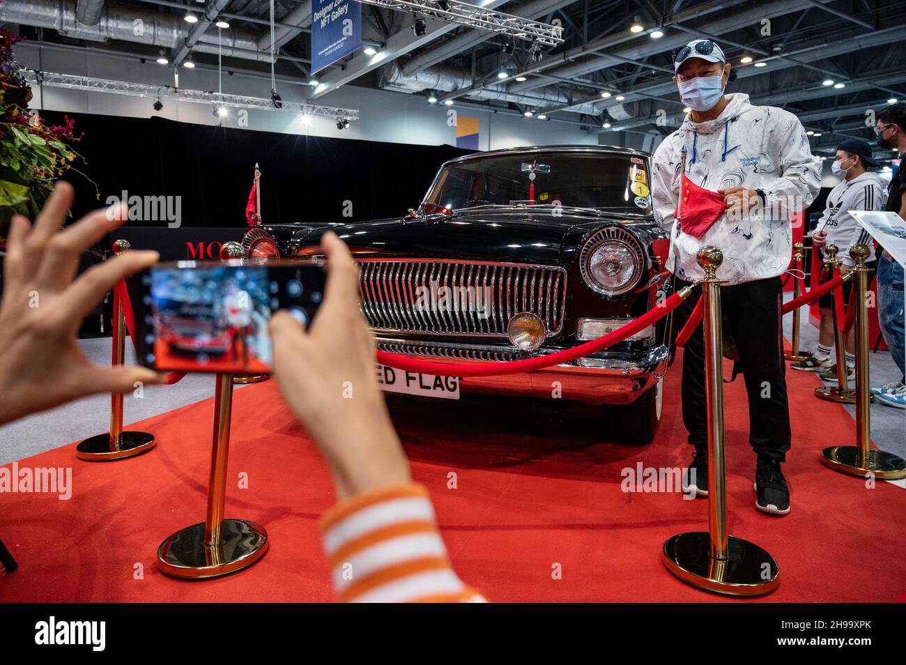 A visitor poses with the Chinese car Hongqi, often used in military ...