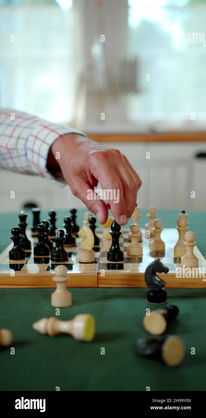A vertical photo of a hand which is playing chess Stock Photo - Alamy
