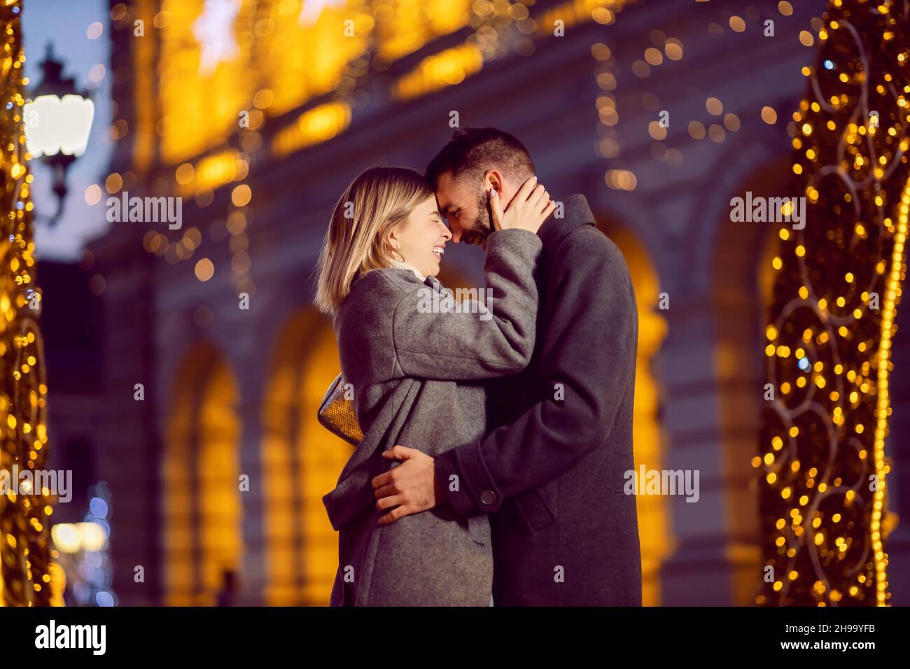 Christmas people cuddling and hugging outdoors on New Year. A happy ...