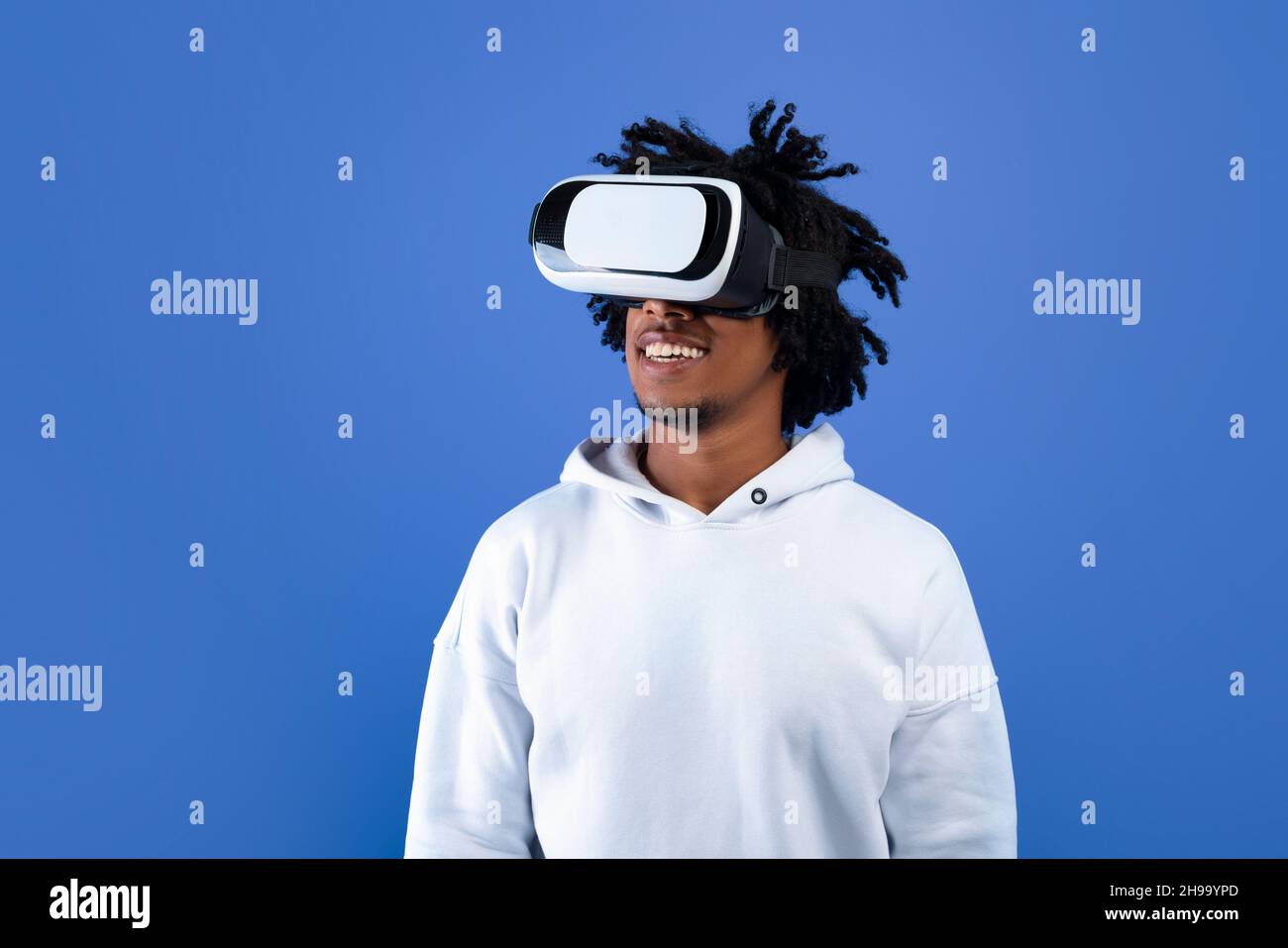Cool African American teen guy wearing VR headset, using virtual ...