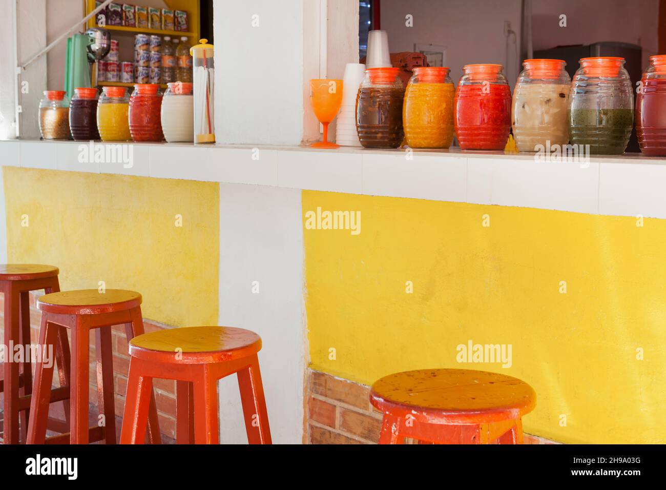 Bar stools,and rows of juice bottles, market stall and drinks stand ...