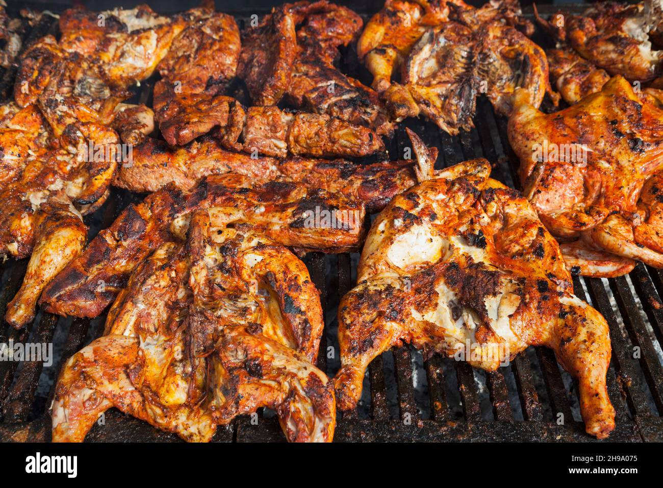 Chickens cooking on a barbeque grill Stock Photo - Alamy