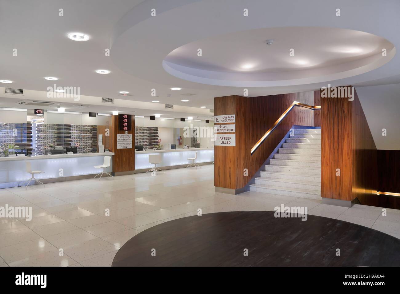 Waiting area and reception desk at a modern hospital, with signs and ...