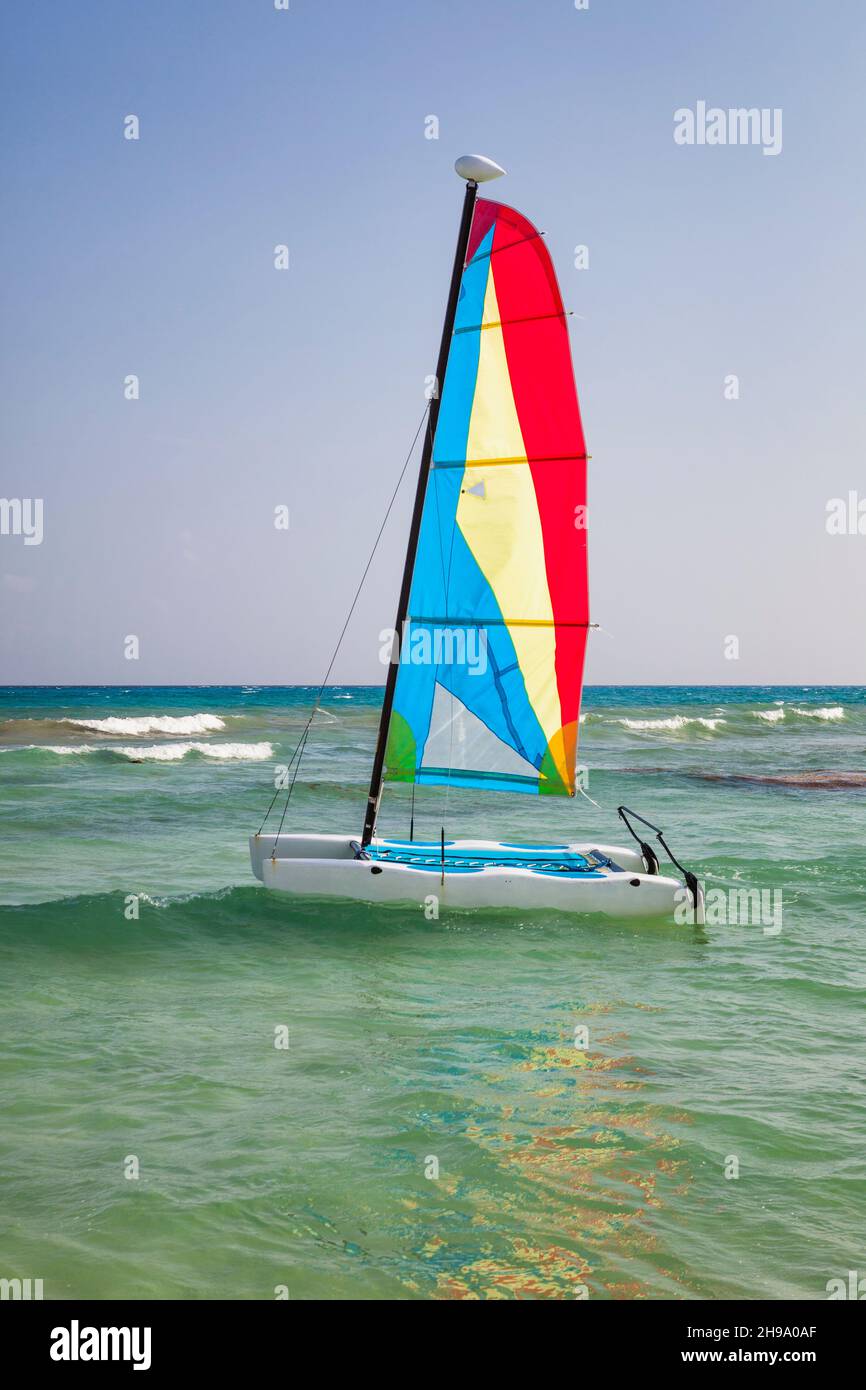 A catamaran in shallow water with the sail up Stock Photo - Alamy