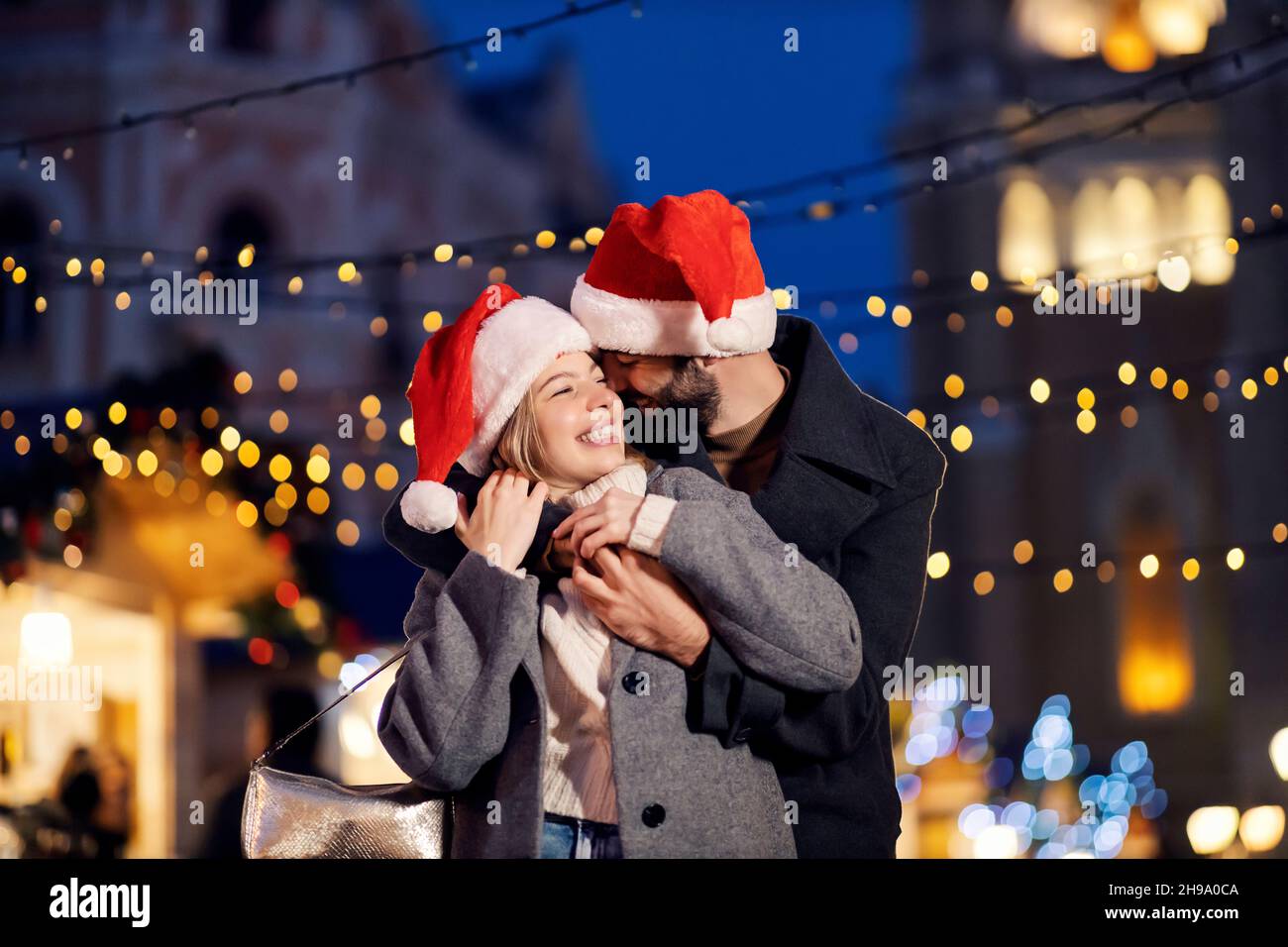 Romantic Christmas couple hugging outdoors on Christmas eve. A young ...