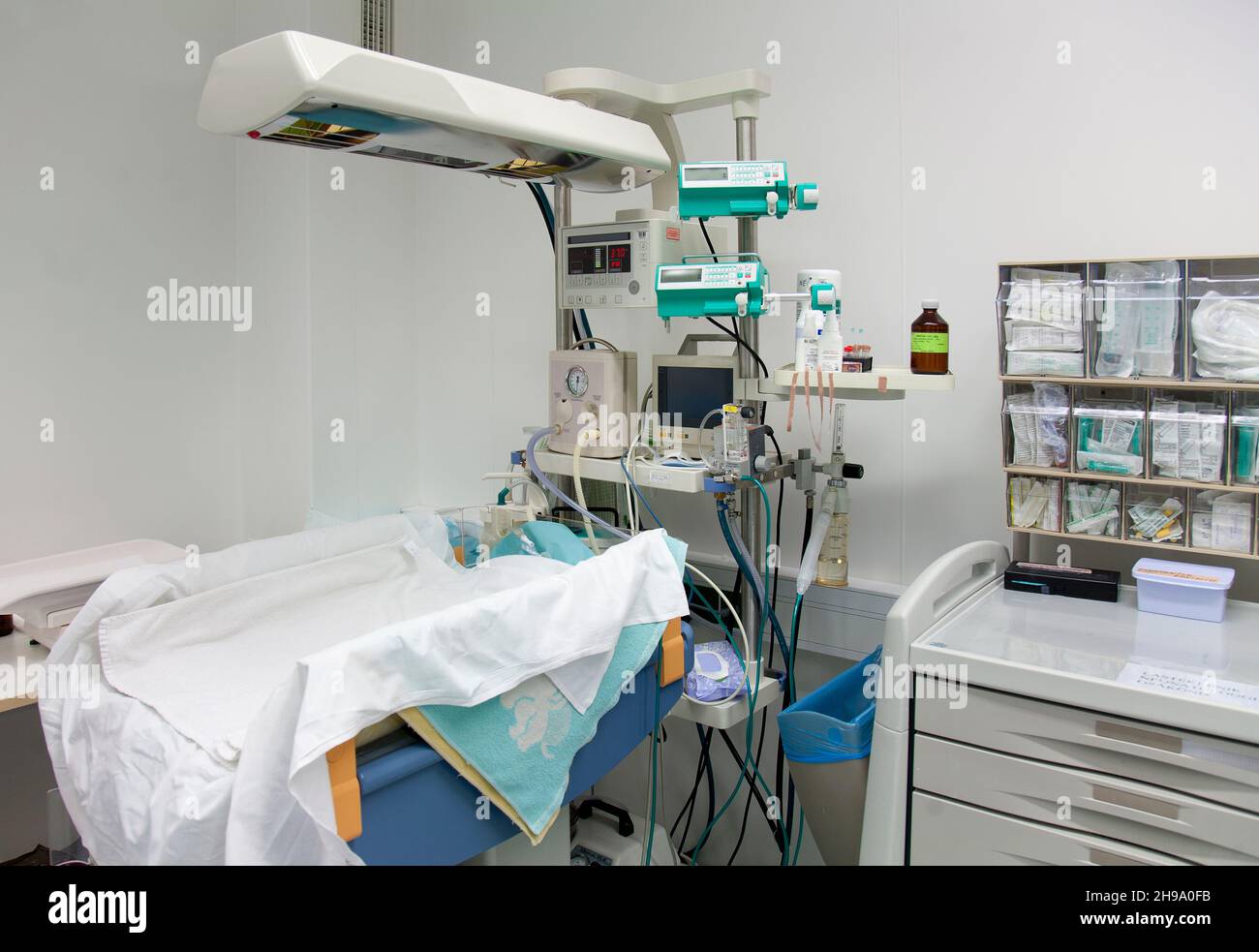 A baby cot with overhead lights in a hospital Stock Photo - Alamy