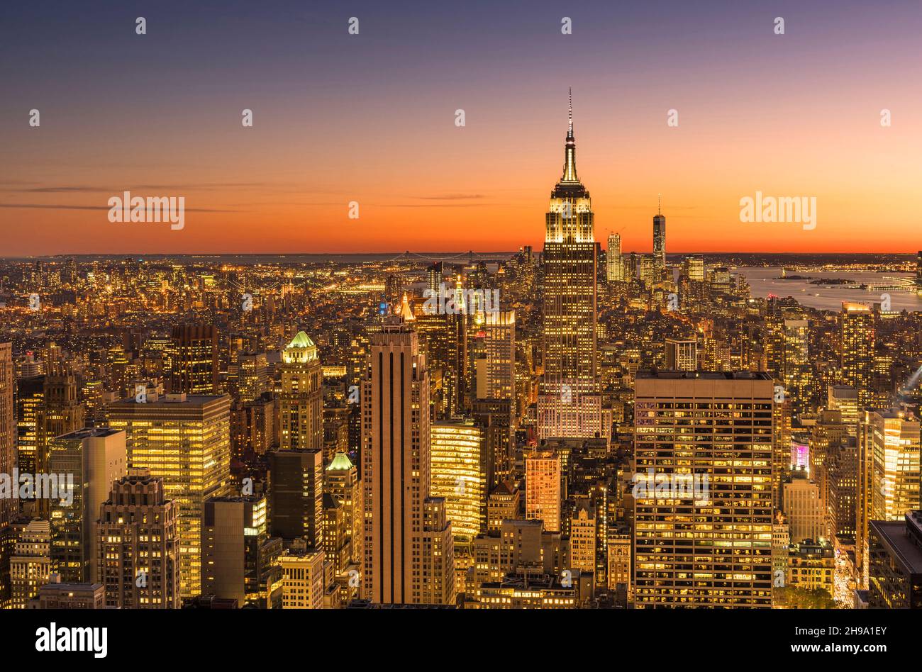 Empire state building rising above Manhattan skyline at sunrise or sunset Stock Photo - Alamy
