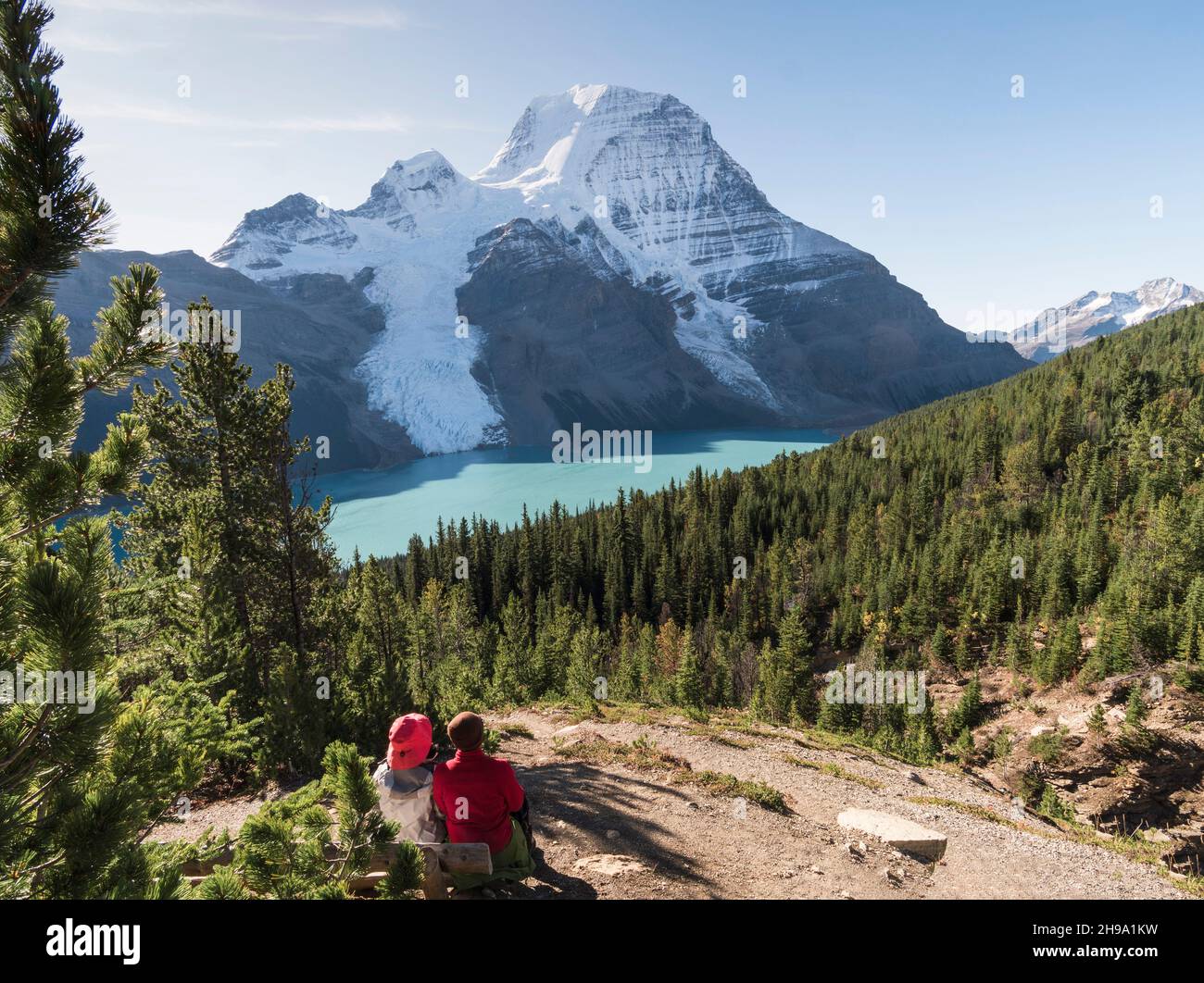 Two people resting by a hiking path, view of Mount Robson and the ...