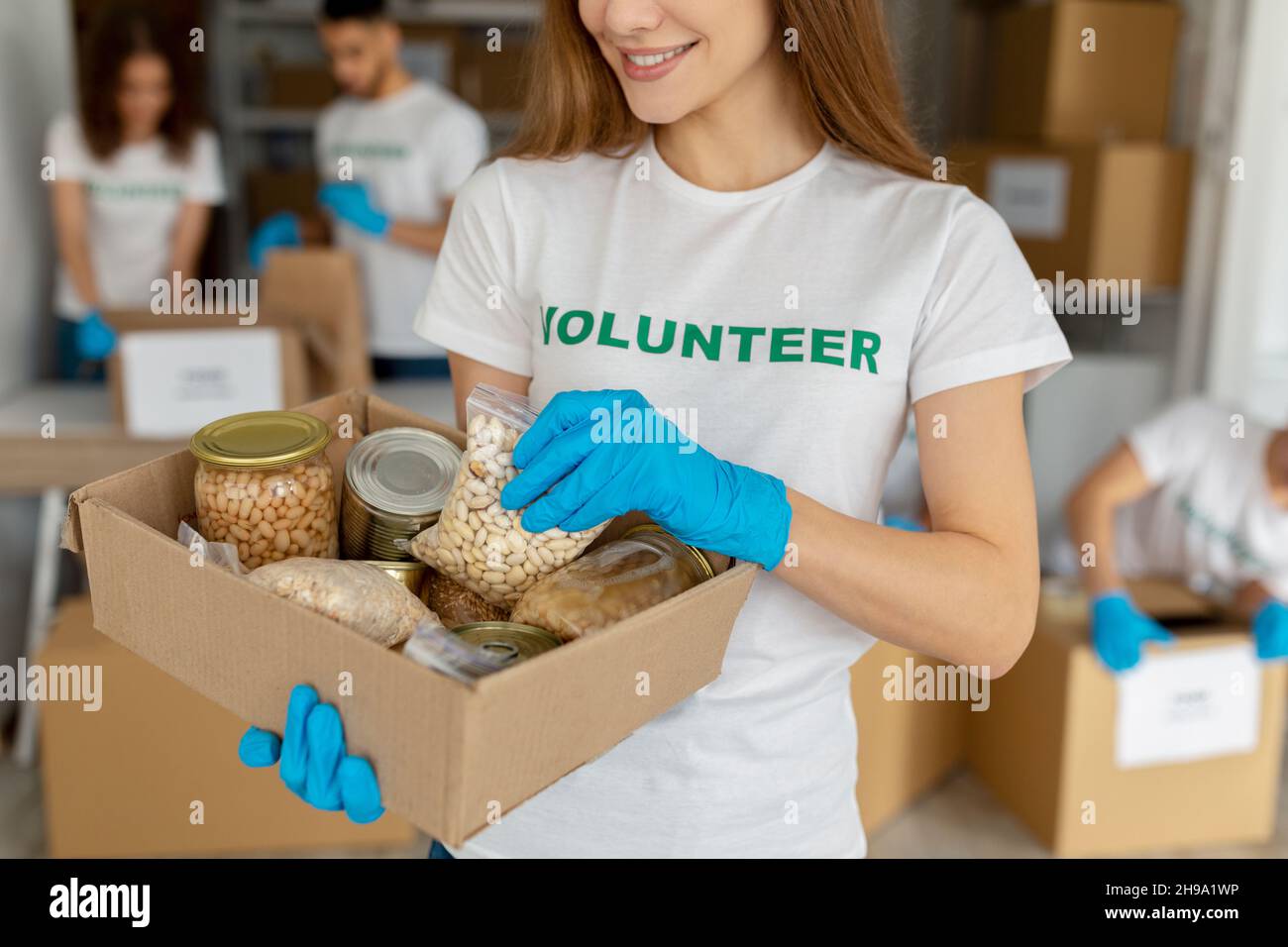 Female activist volunteer working at charity center, holding box with ...