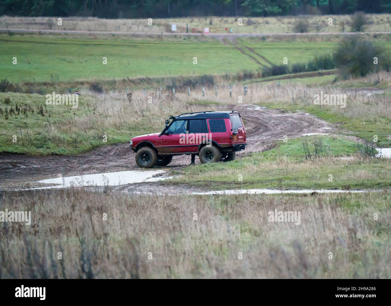 4x4 off-road vehicles driving across mud and water-logged terrain ...