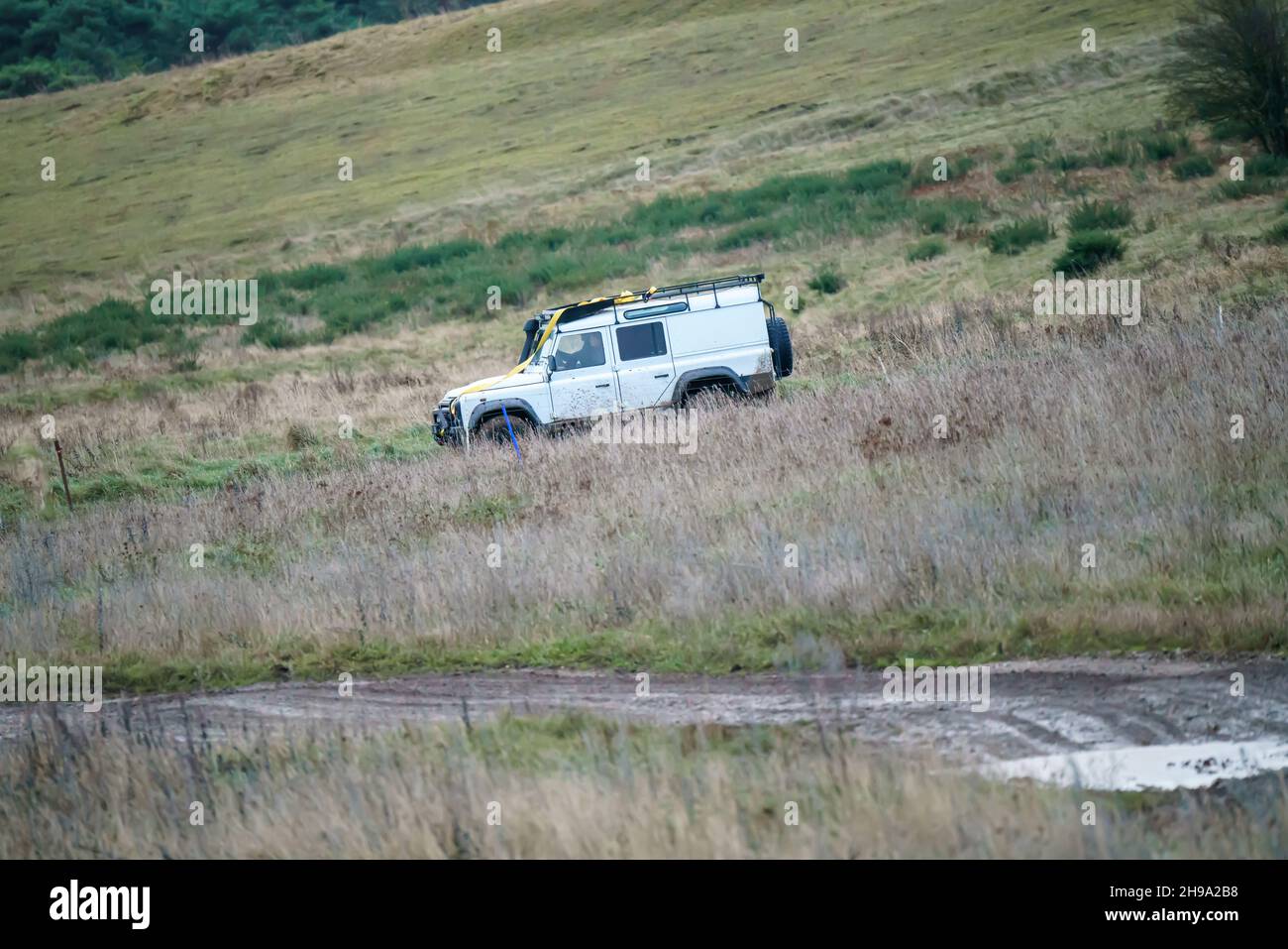 4x4 off-road vehicles driving across mud and water-logged terrain ...