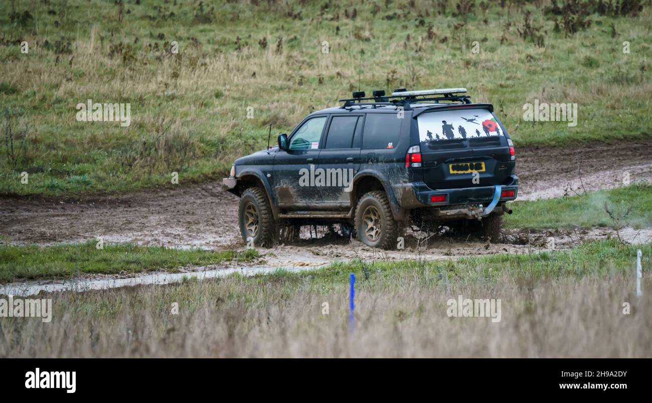 4x4 off-road vehicles driving across mud and water-logged terrain ...