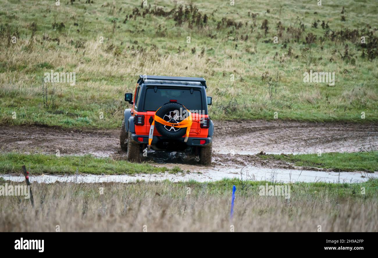4x4 off-road vehicles driving across mud and water-logged terrain ...