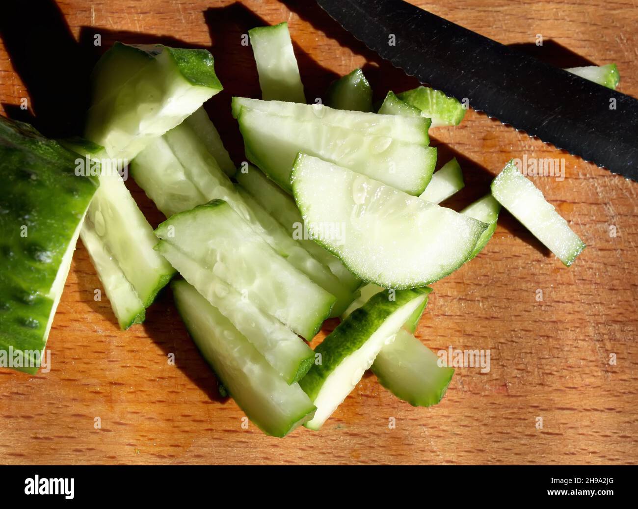 Sliced fresh green cucumbers in a wooden board close up Stock Photo - Alamy