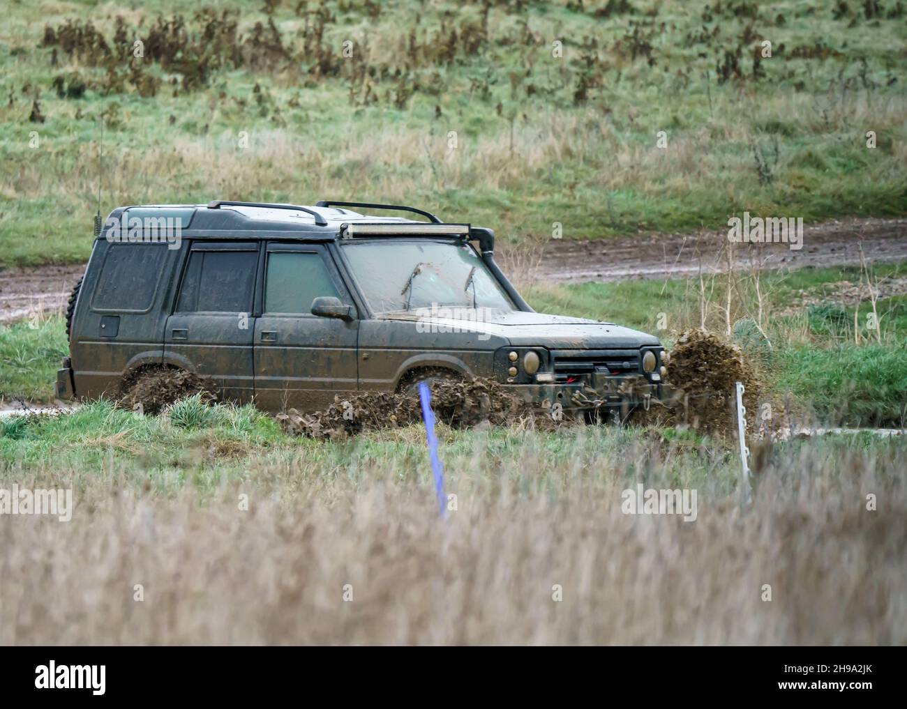 4x4 off-road vehicles driving across mud and water-logged terrain ...