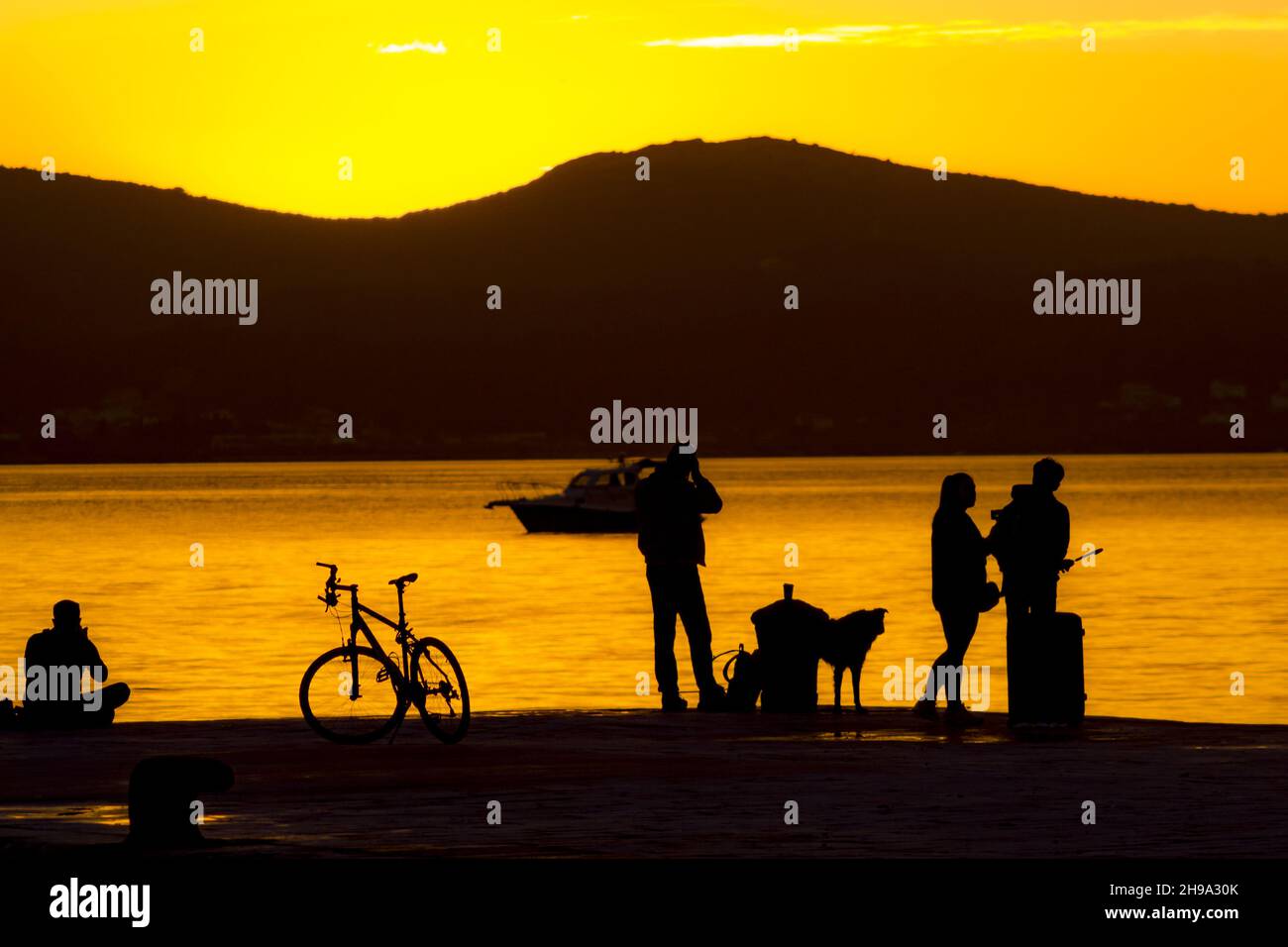 A group of friends on the beach under a sunset sky Stock Photo - Alamy