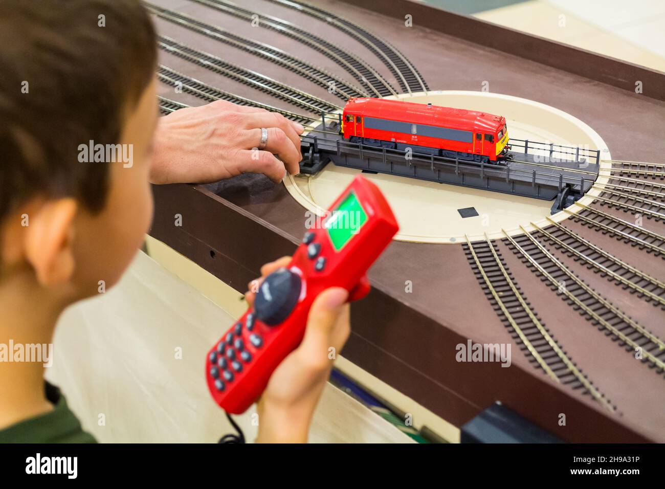 Boy child operating locomotive with Roco 10810 Z21 multiMAUS device at ...