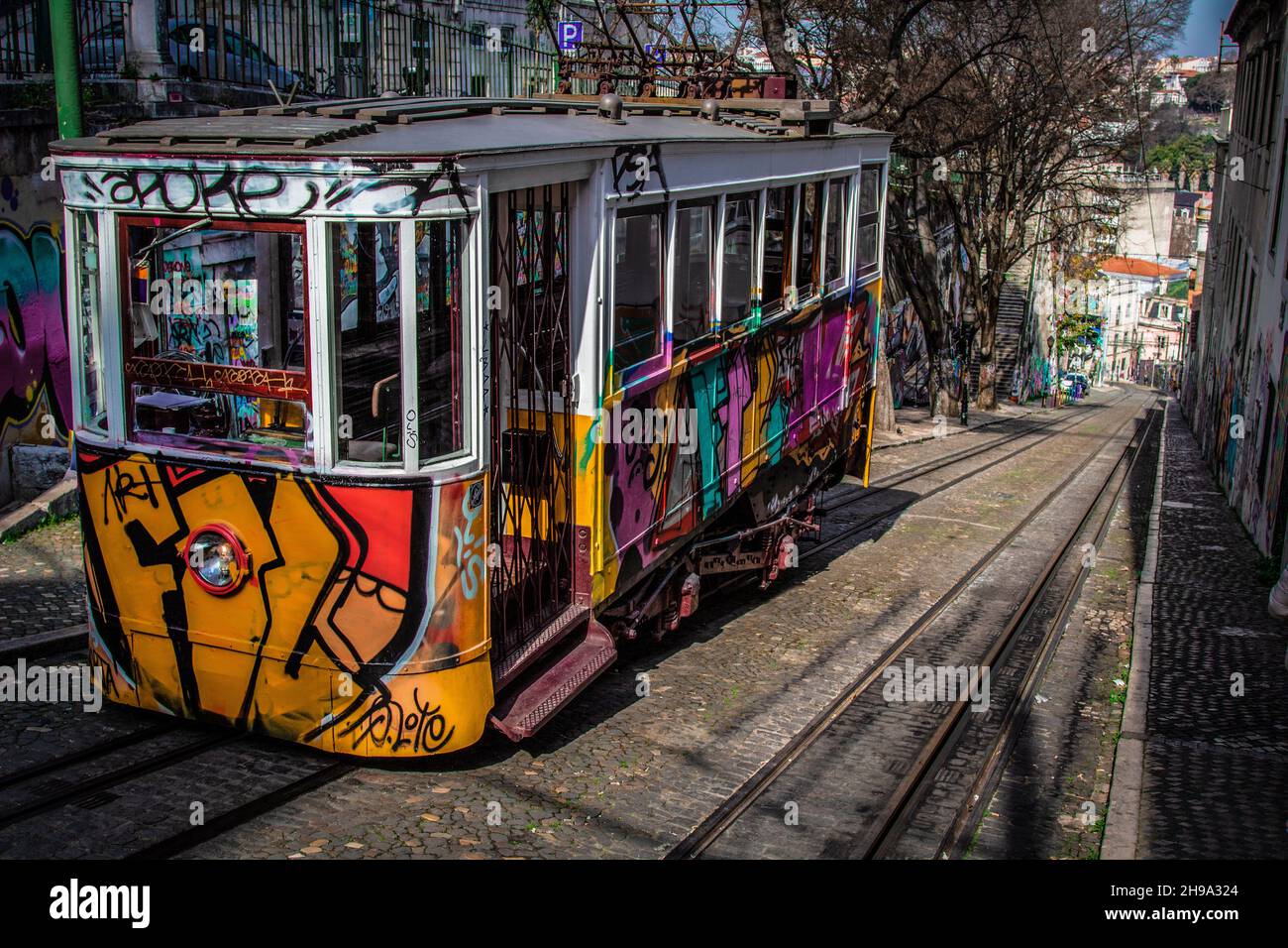 Graffiti covered tram in Lisbon, Portugal. The Glória Funicular, civil ...