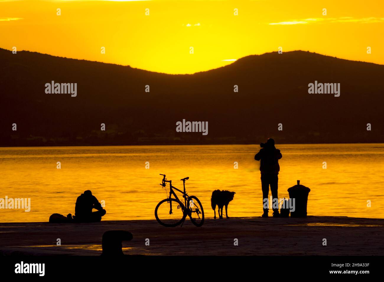 A group of friends on the beach under a sunset sky Stock Photo - Alamy