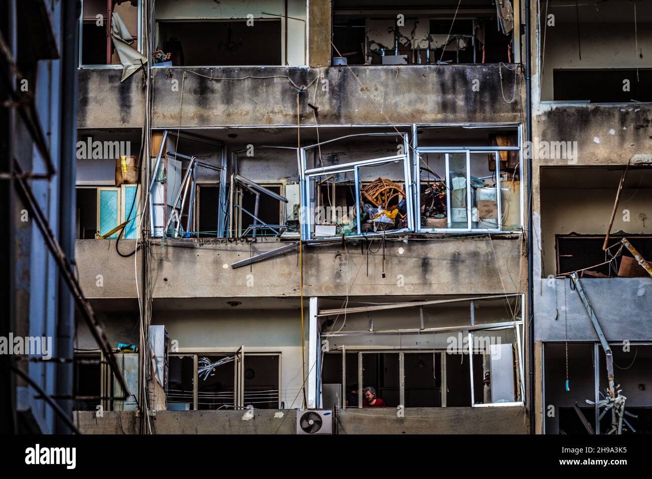 An abandoned residential building facade with broken balconies full of ...
