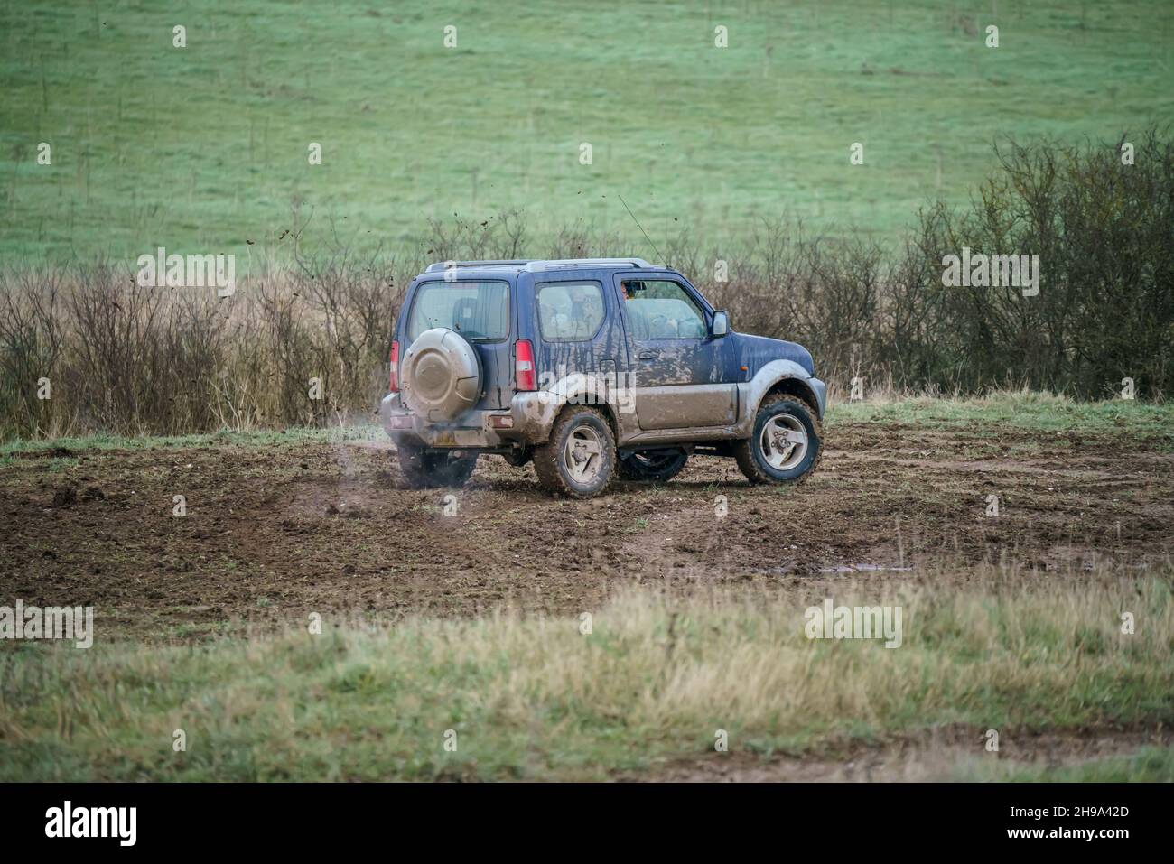 4x4 off-road vehicles driving across mud and water-logged terrain ...