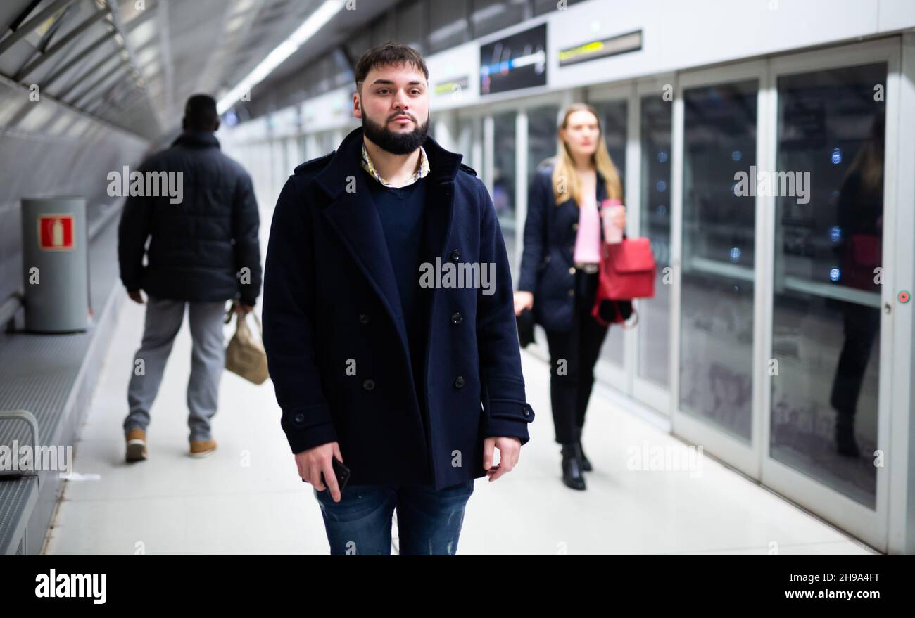 Young man waiting for subway train Stock Photo - Alamy