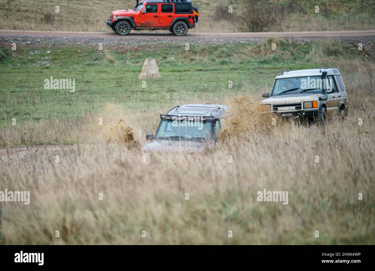 4x4 off-road vehicles driving across mud and water-logged terrain ...